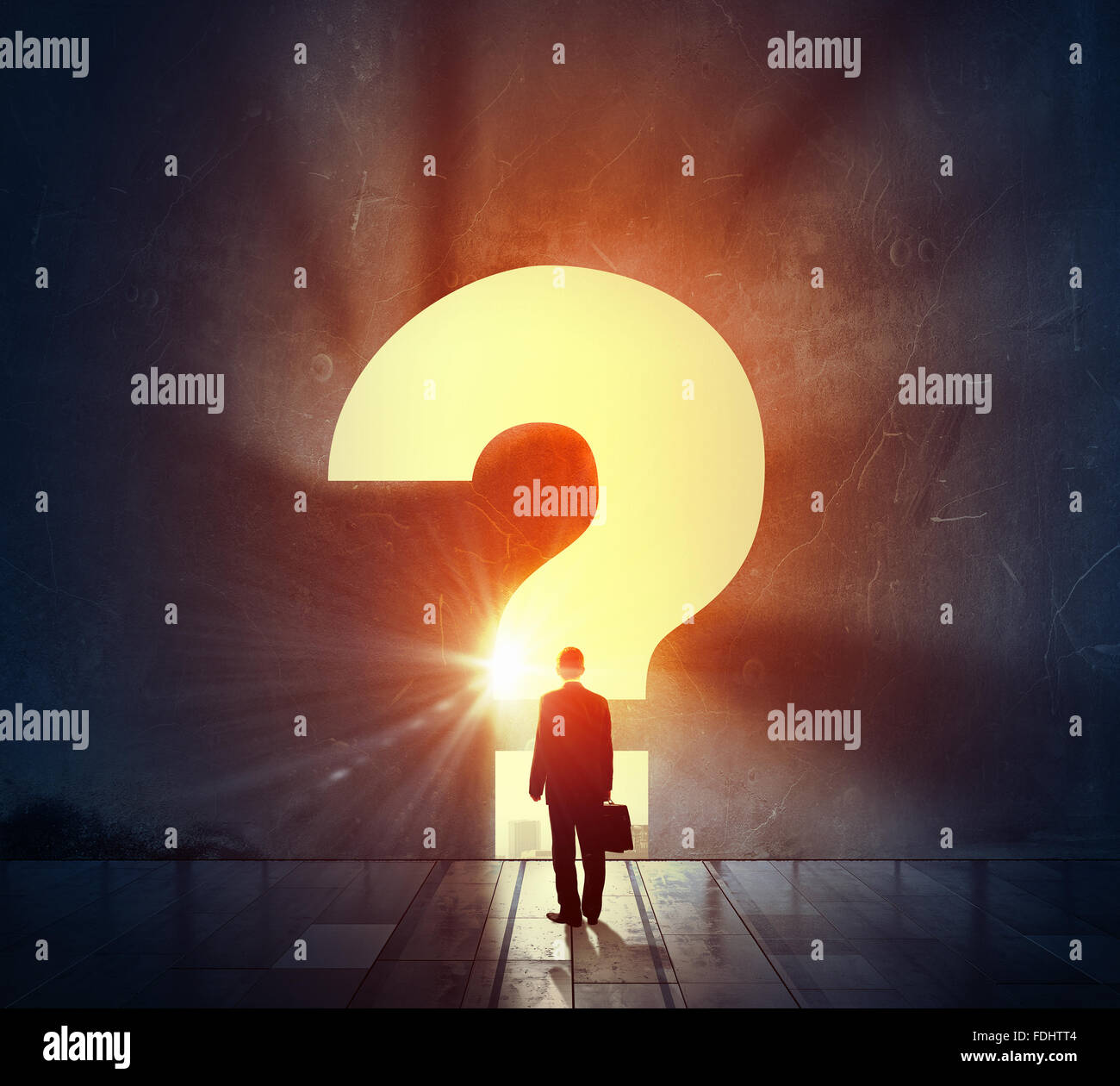 Back view of businessman standing in light of big question mark Stock ...
