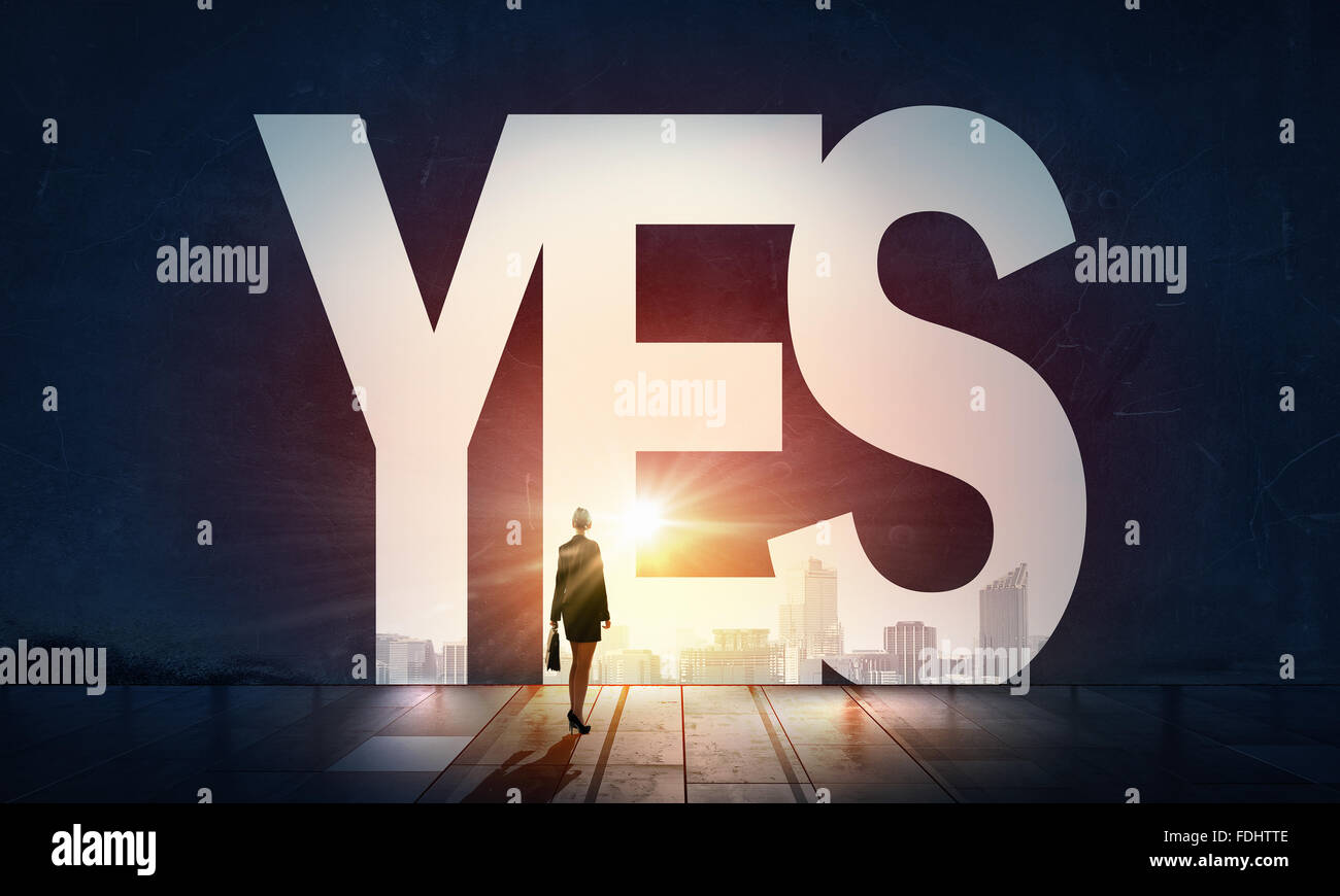 Back view of businesswoman standing in light word yes Stock Photo - Alamy