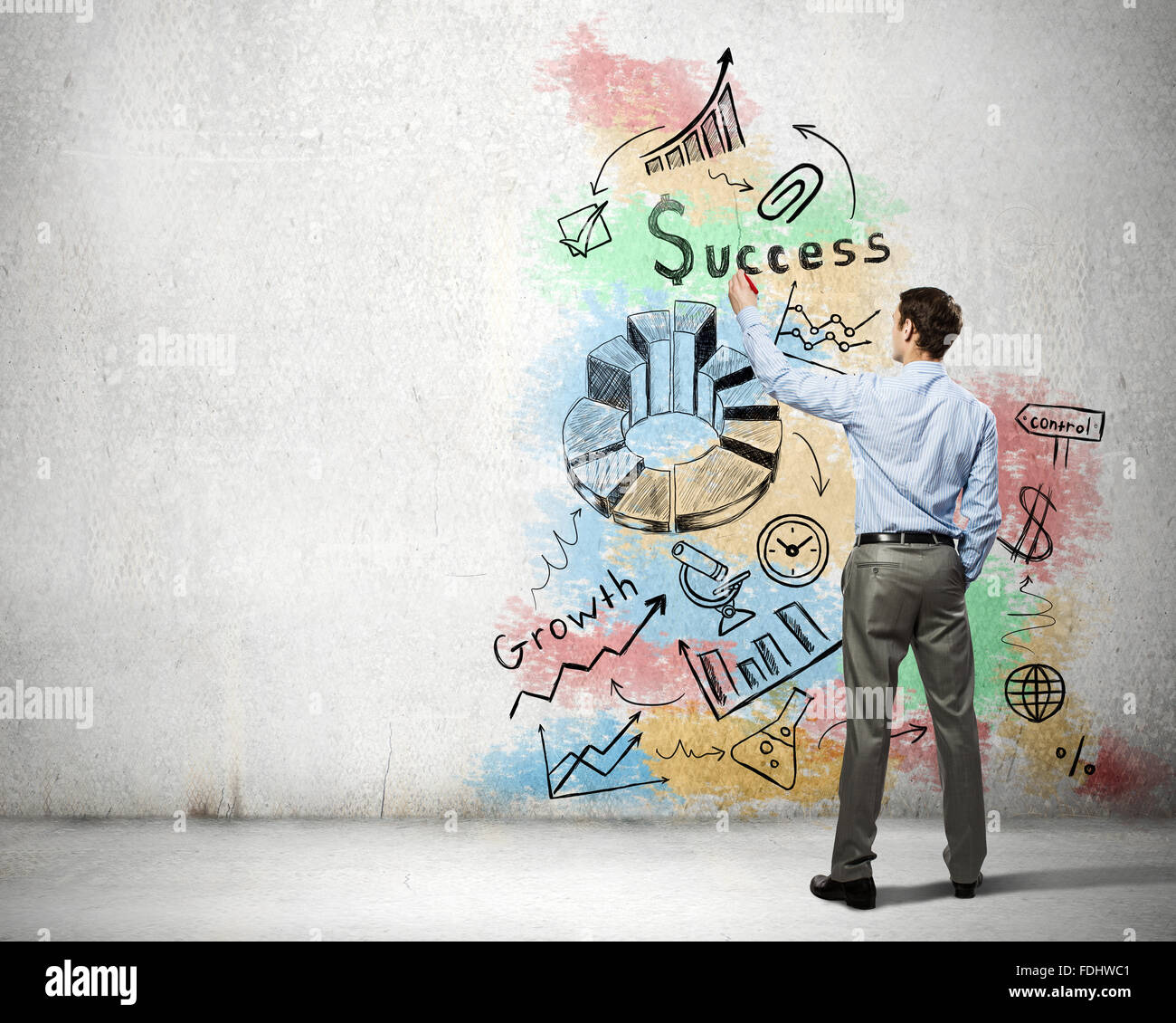 Back view of businessman drawing business sketches on wall Stock Photo ...
