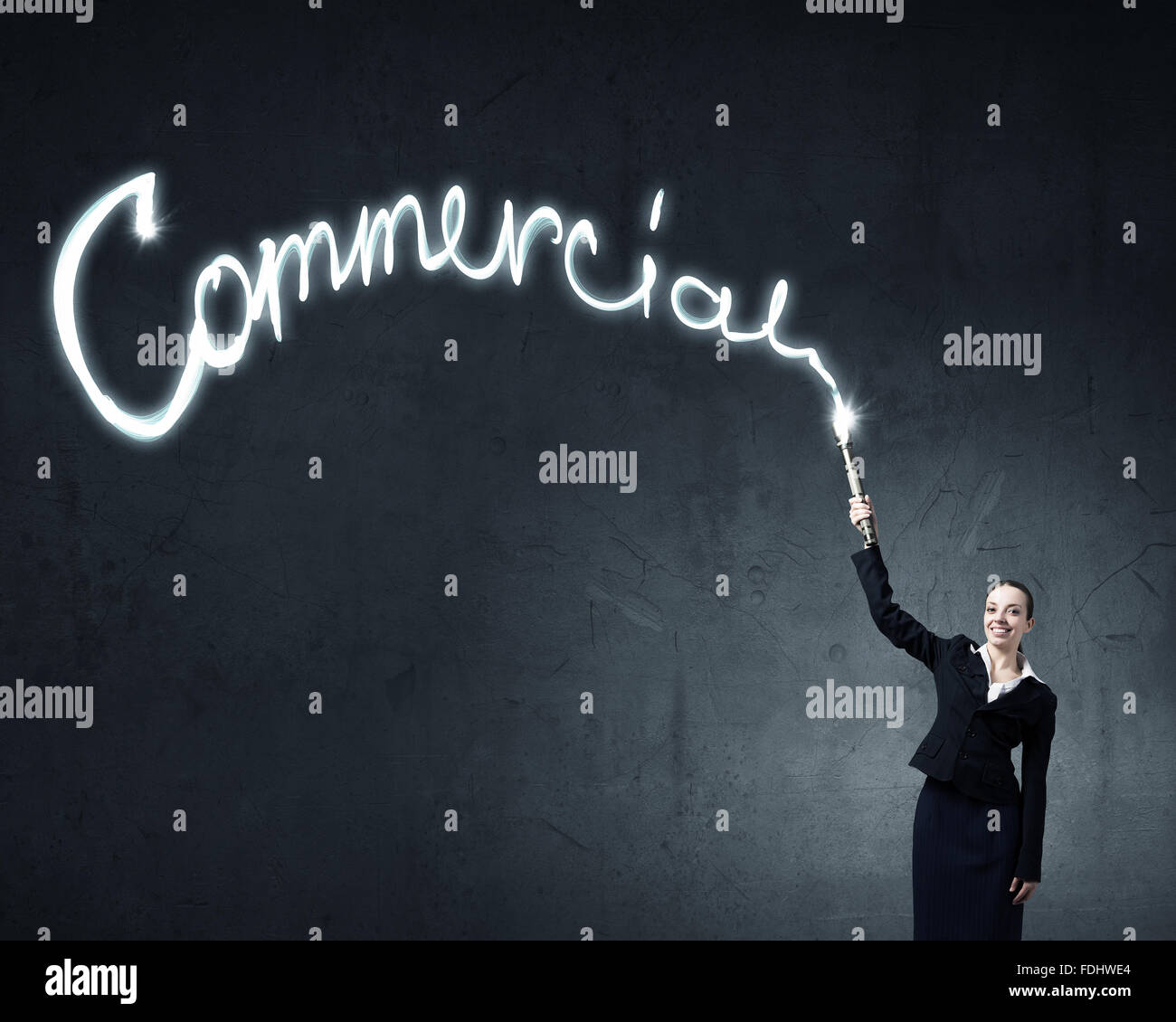 Businesswoman in darkness drawing word commercial with flashlight Stock ...