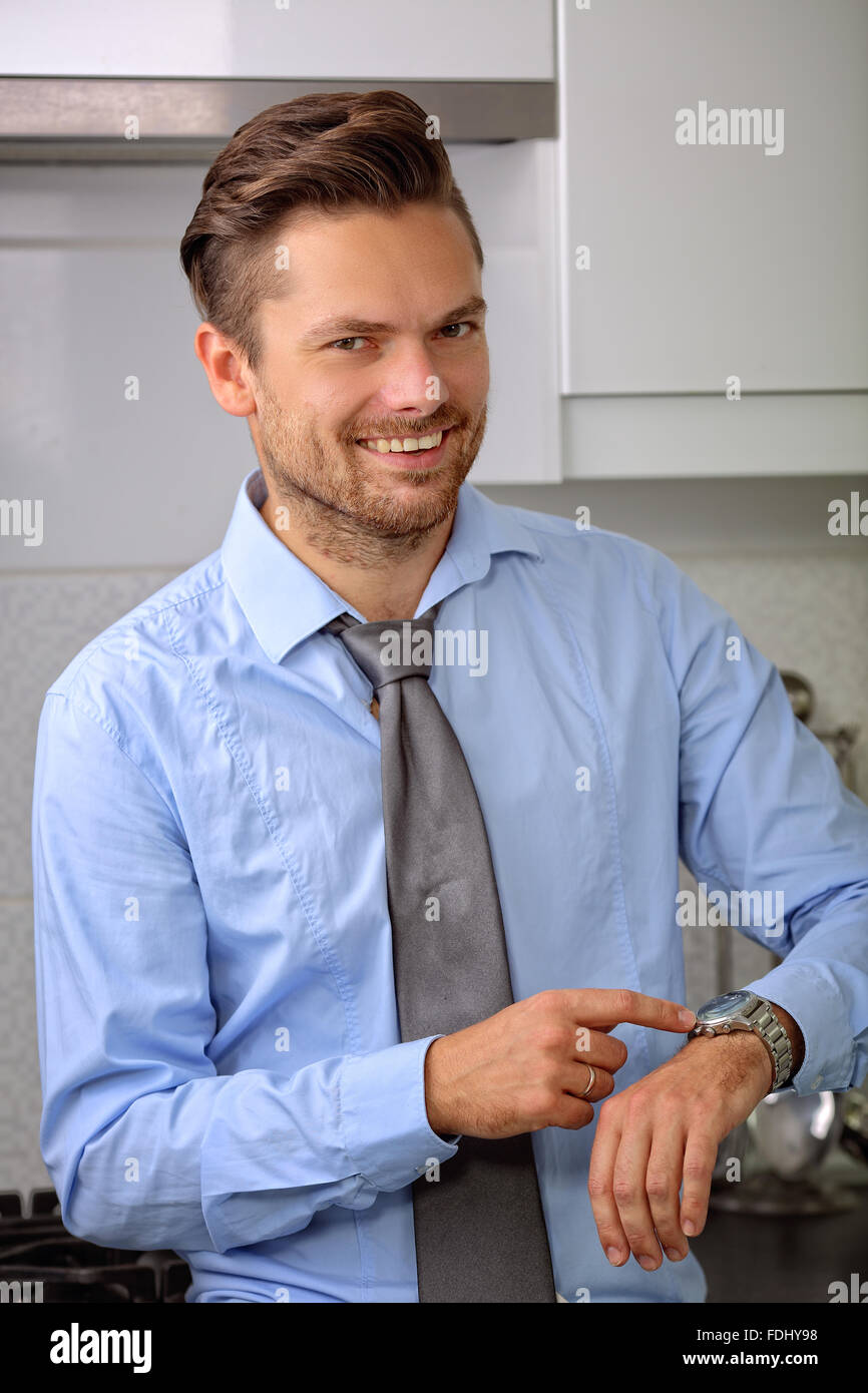 handsome man getting ready for work and shows that he has little time ...