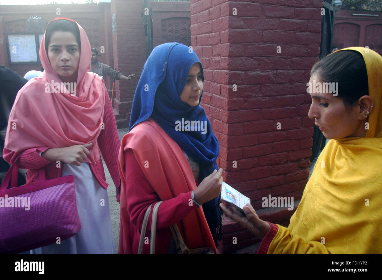Lahore. 1st Feb, 2016. A woman checks the identity card of a student at ...