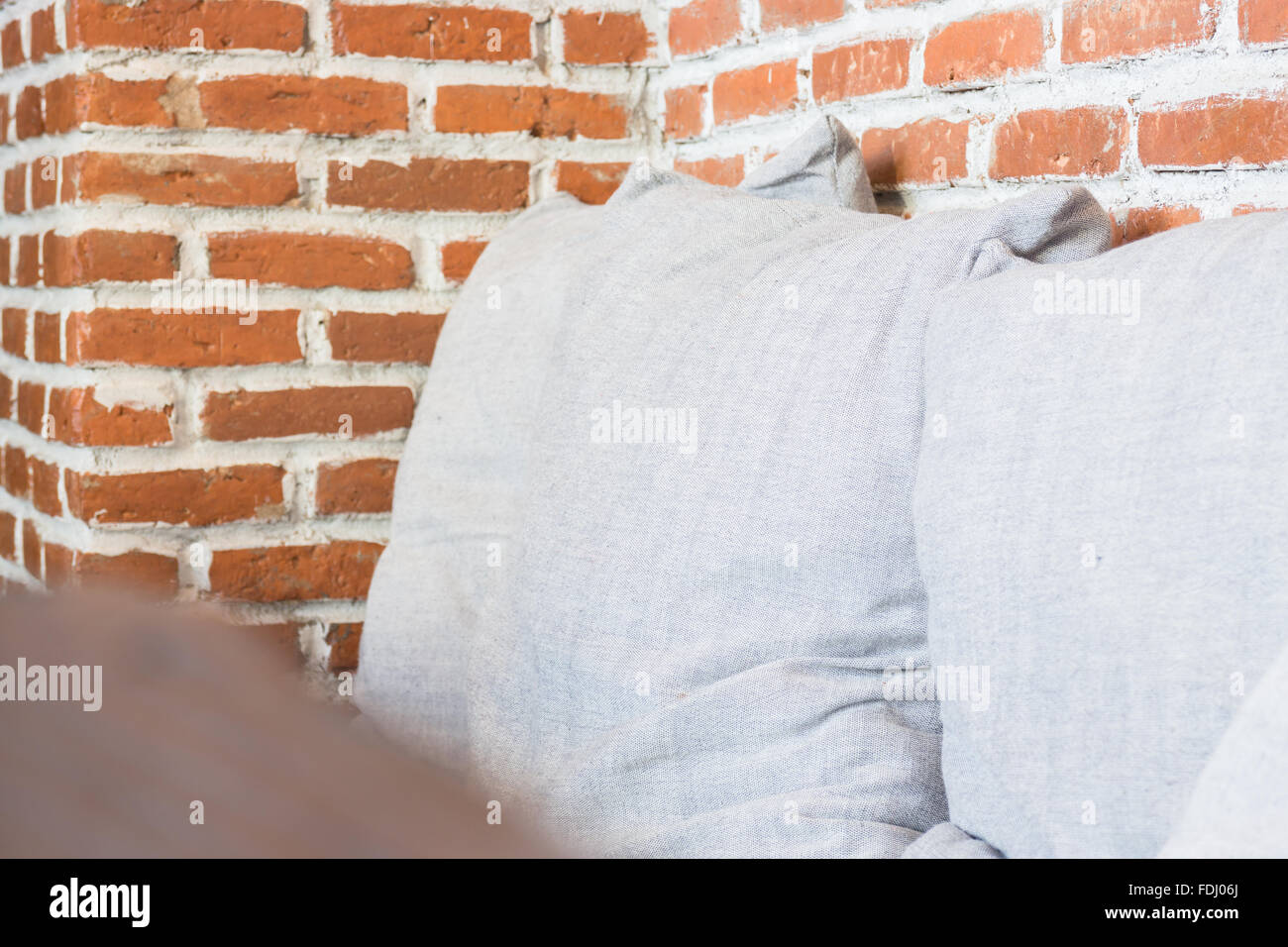 Grey pillow on a brick wall background, stock photo Stock Photo - Alamy