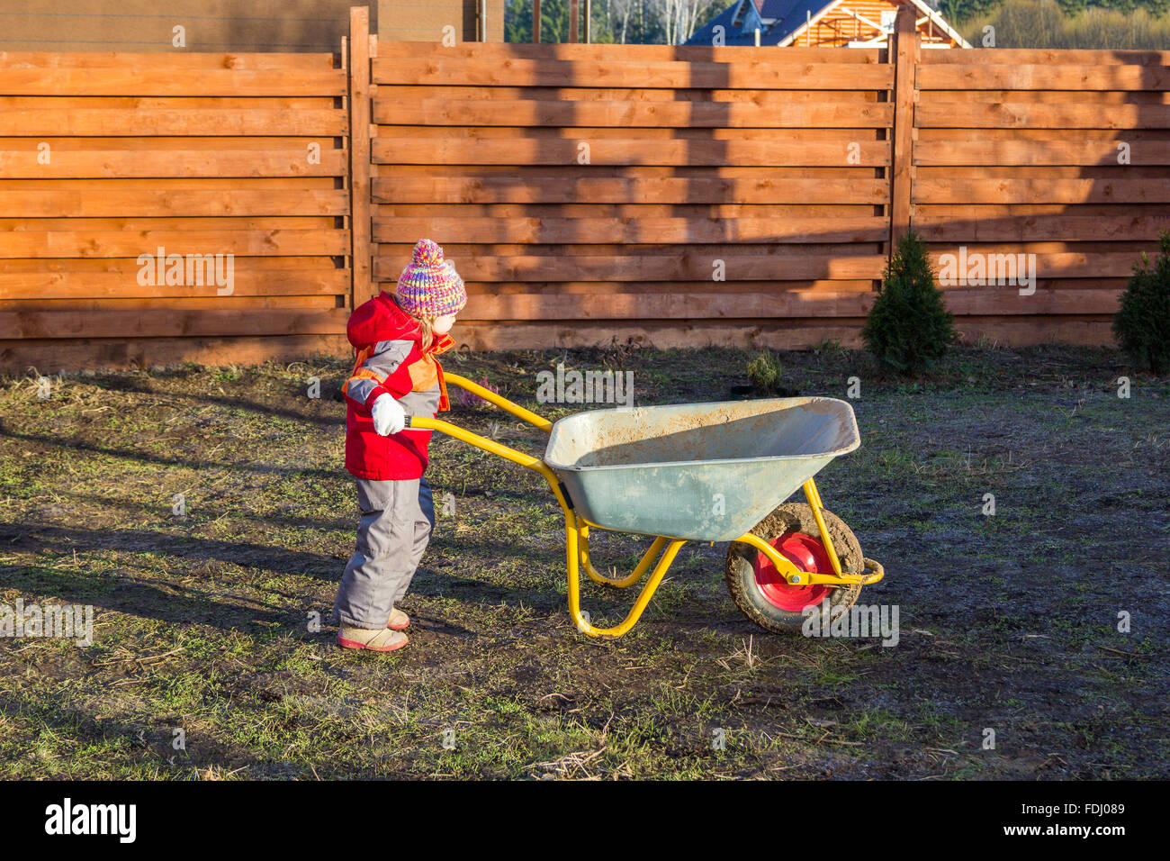 little girl pushing a garden wheelbarrow Stock Photo - Alamy