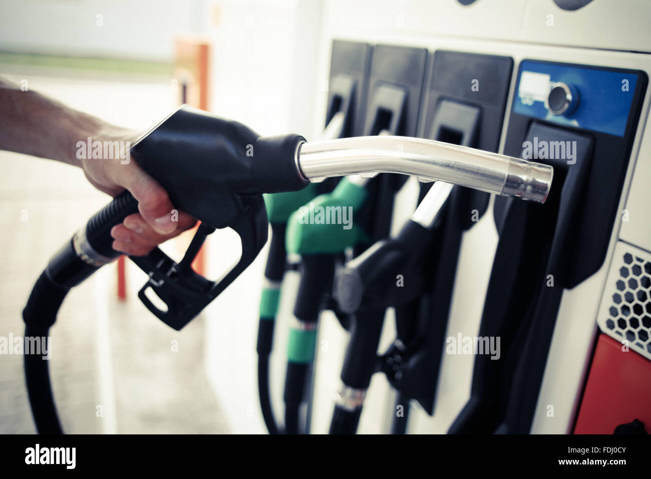 Detail of a hand holding a fuel pump at a station Stock Photo - Alamy