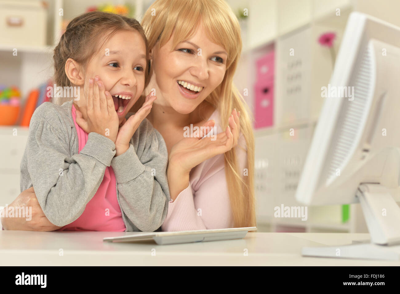 girl playing with mother on computer Stock Photo - Alamy
