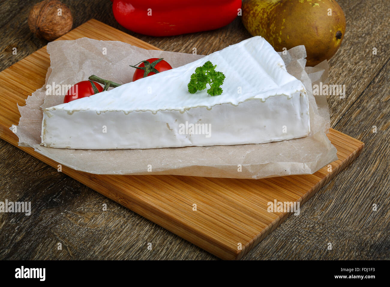 Brie cheese triangle with tomato and parsley Stock Photo - Alamy