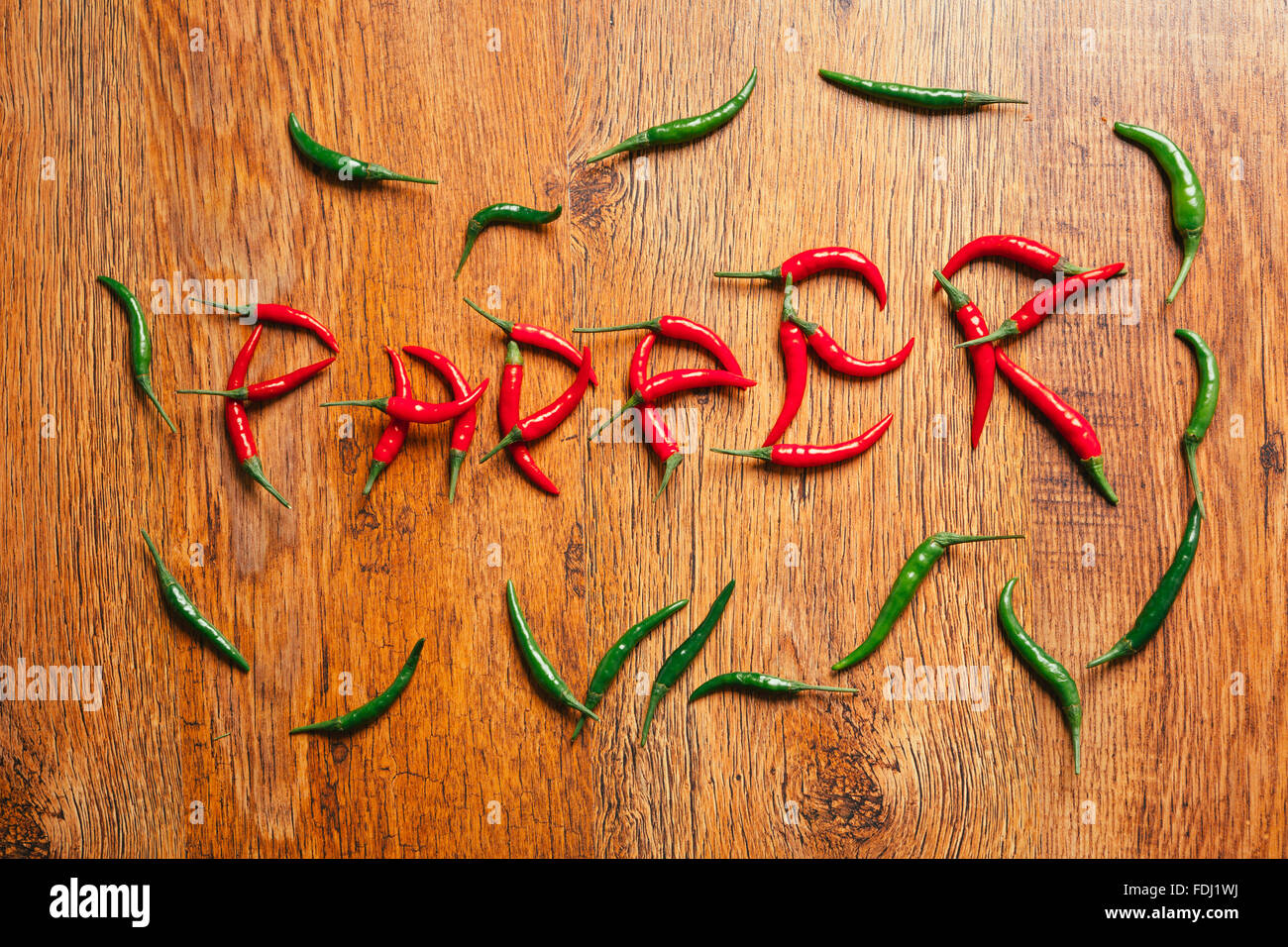 word from chili peppers on a wooden background Stock Photo - Alamy