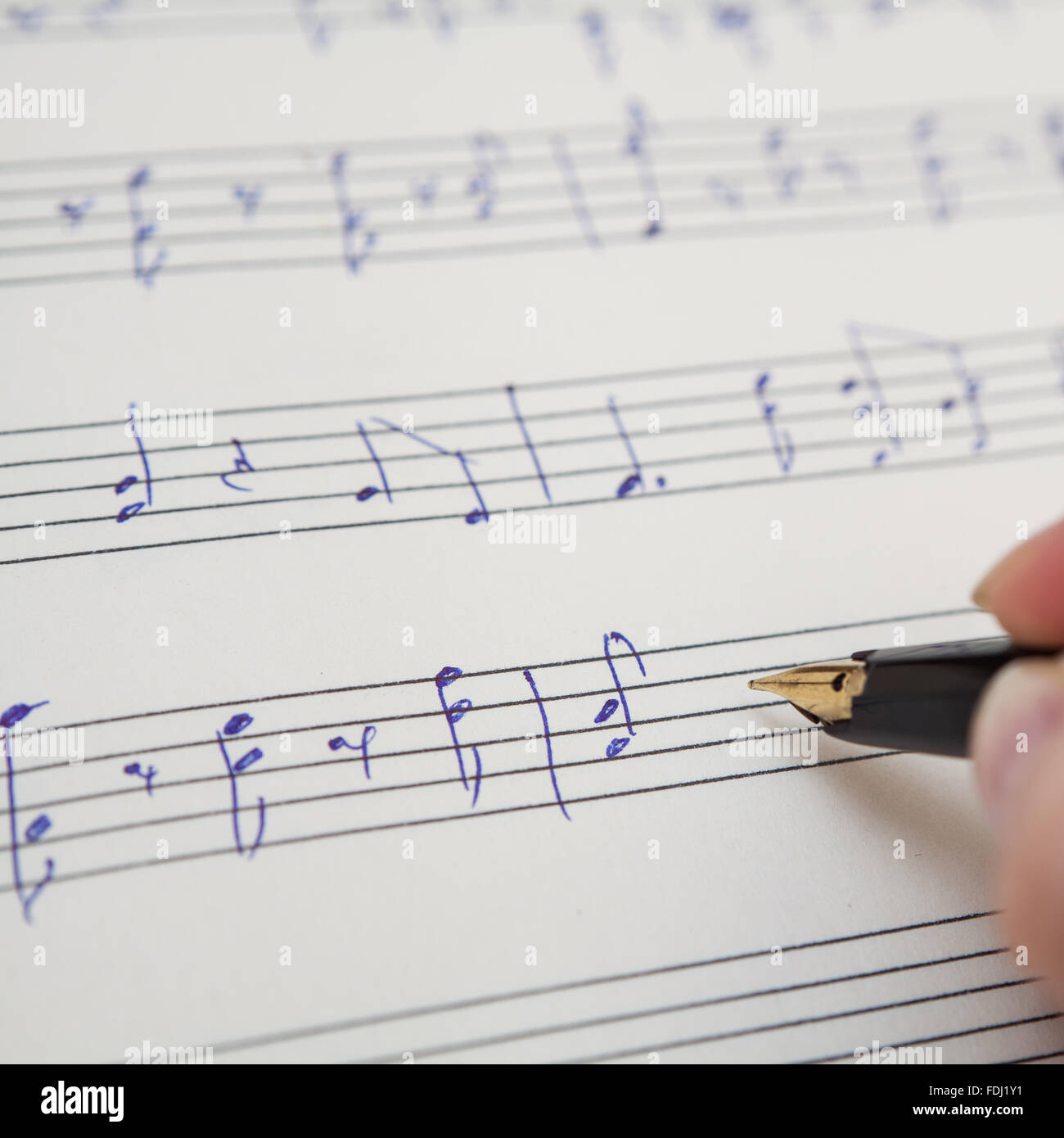 Hand with pen and music sheet Stock Photo - Alamy