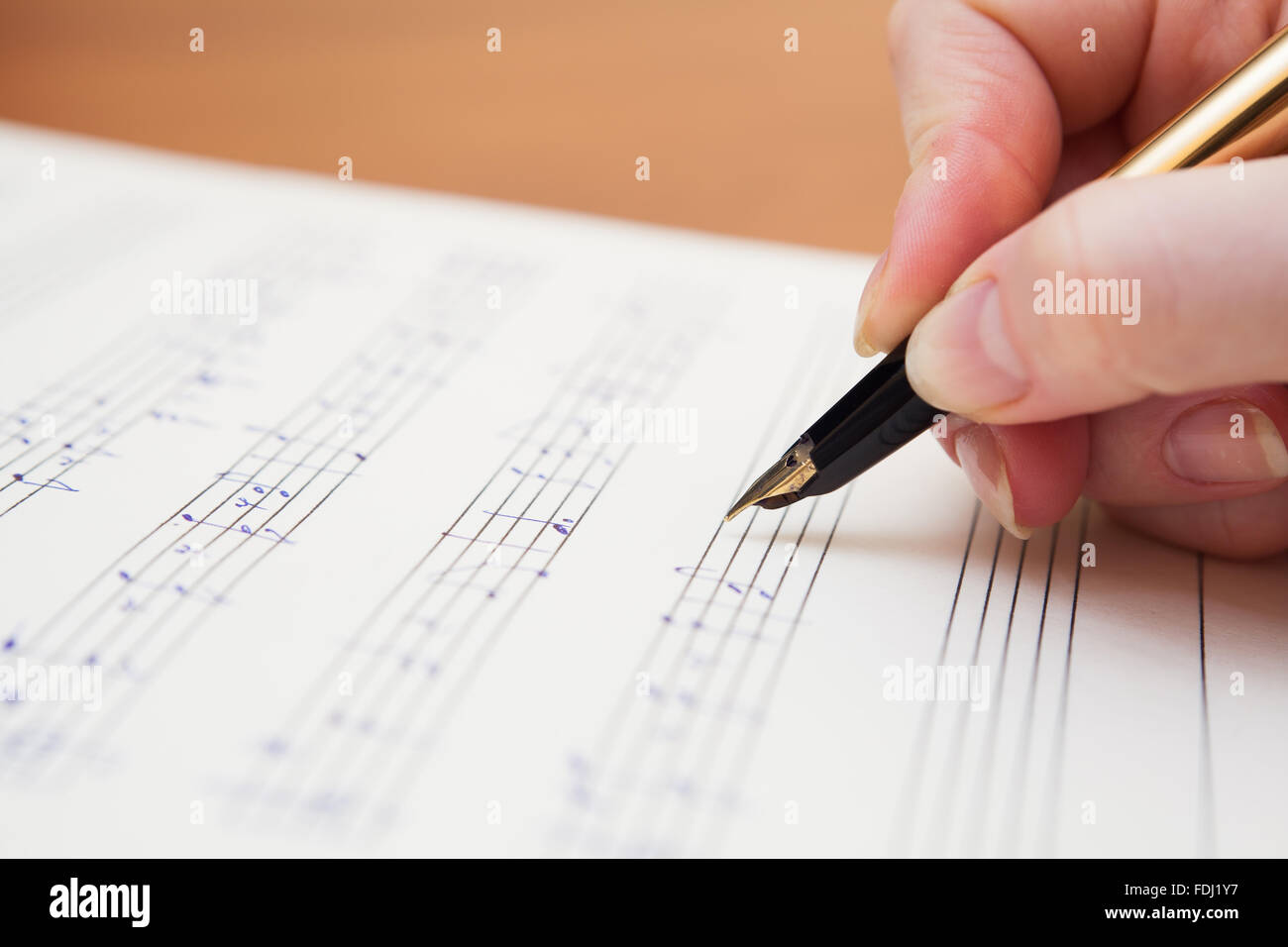 Hand with pen and music sheet Stock Photo - Alamy