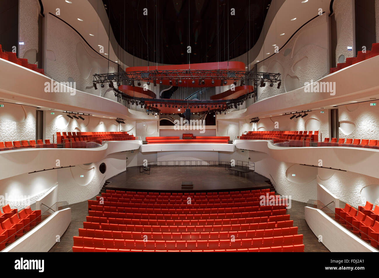Main hall, with red seating against curving white walls and balconies ...