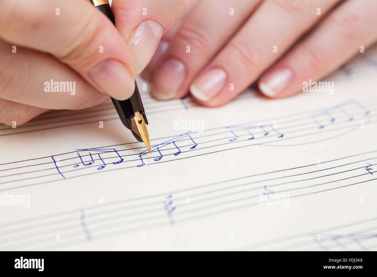 Hand with pen and music sheet Stock Photo - Alamy