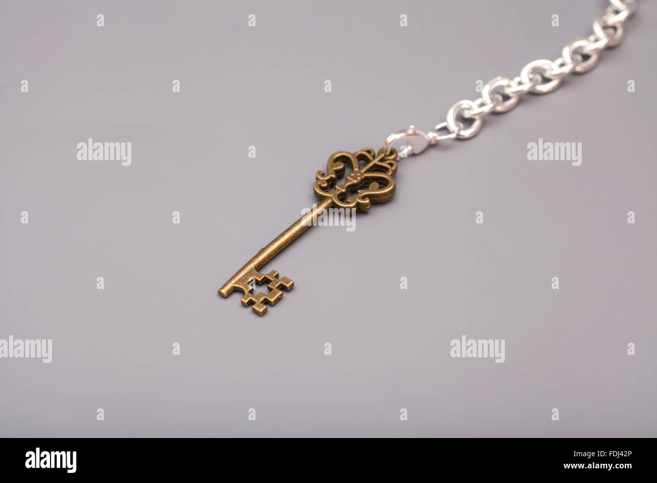 Vintage Key with chain on gray background Stock Photo - Alamy