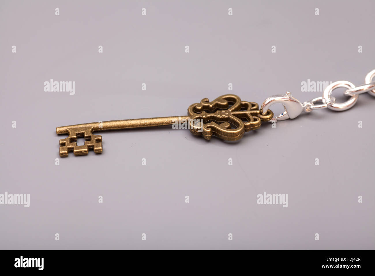 Vintage Key with chain on gray background Stock Photo - Alamy