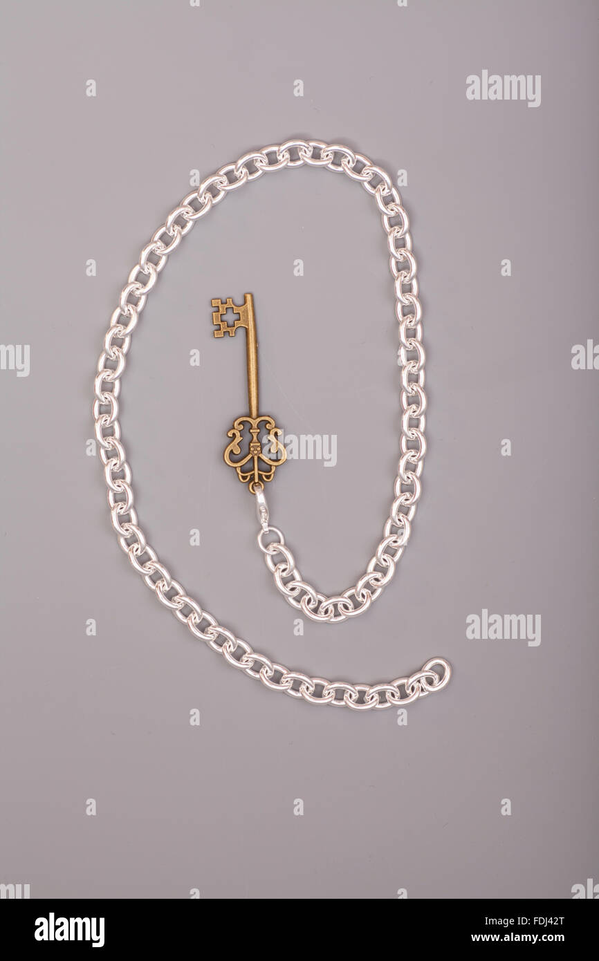 Vintage Key with chain on gray background Stock Photo - Alamy