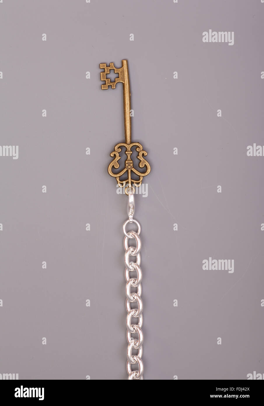 Vintage Key with chain on gray background Stock Photo - Alamy
