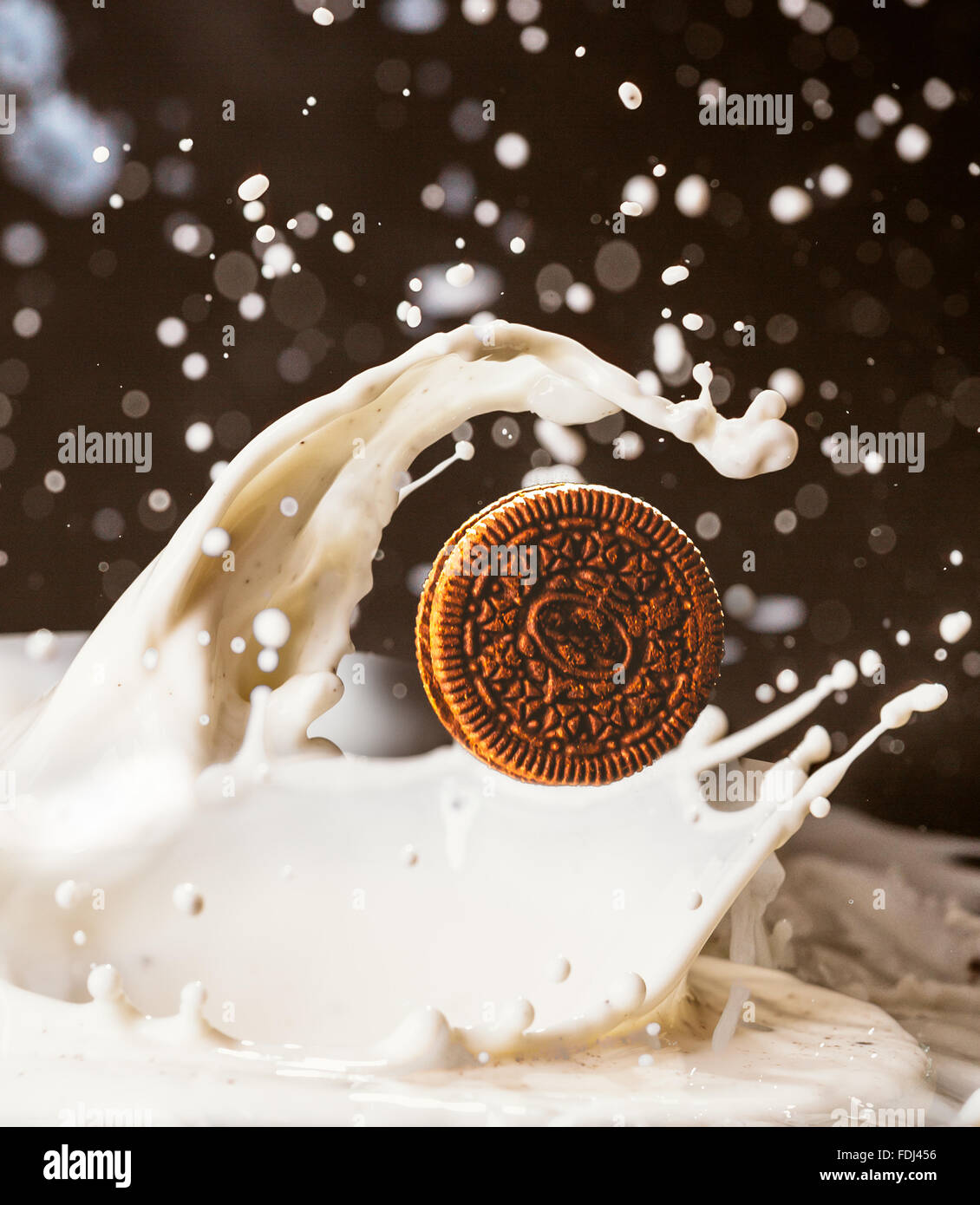cookies and milk splash on dark background Stock Photo - Alamy