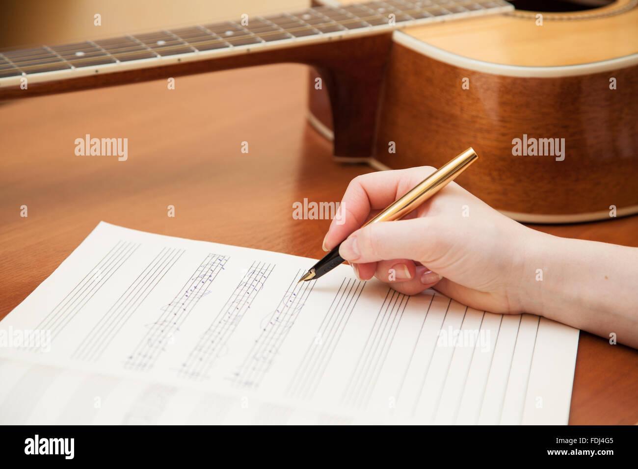 Hand with pen and music sheet Stock Photo - Alamy