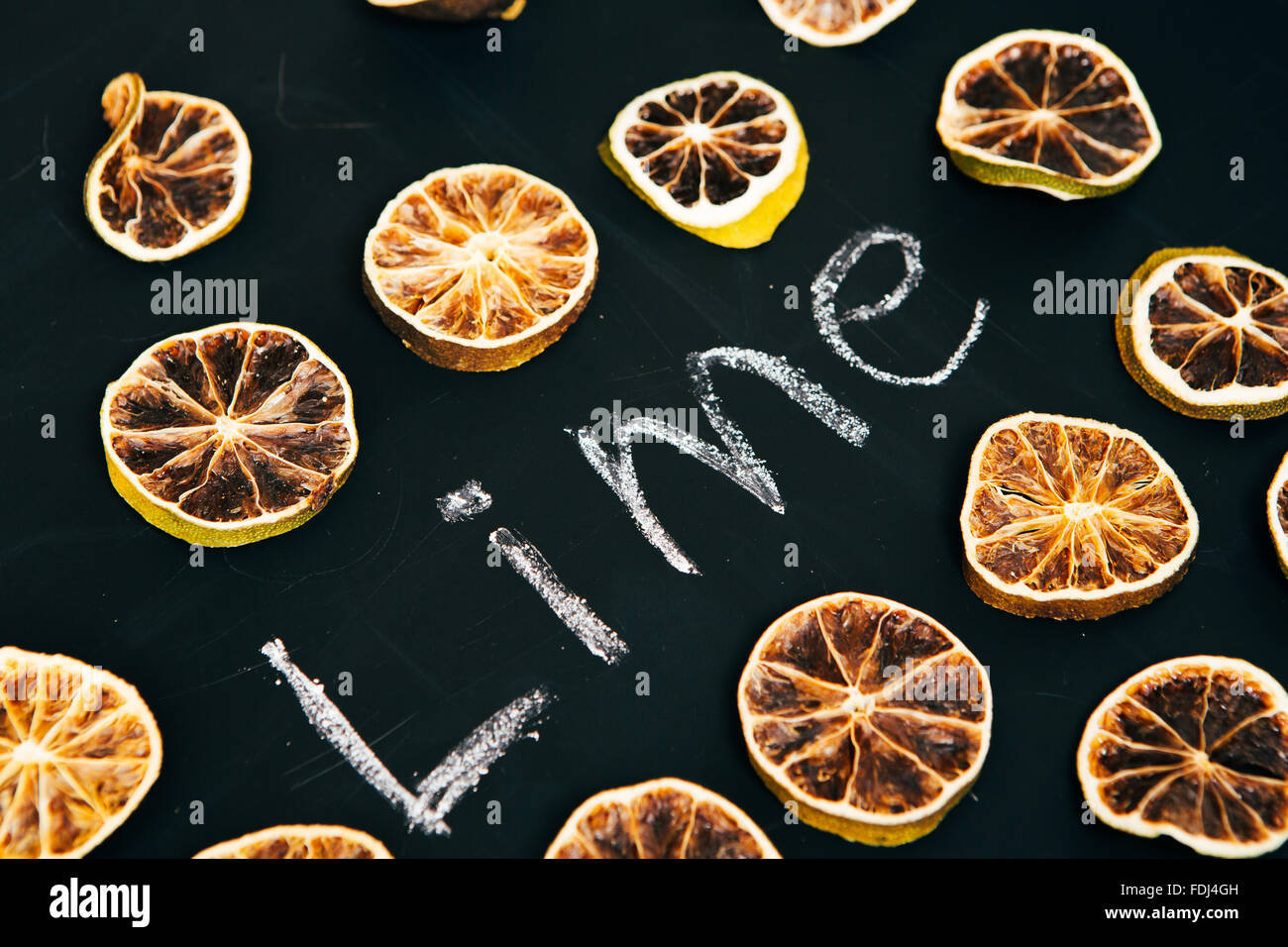 many cut orange circle on a black background board Stock Photo - Alamy