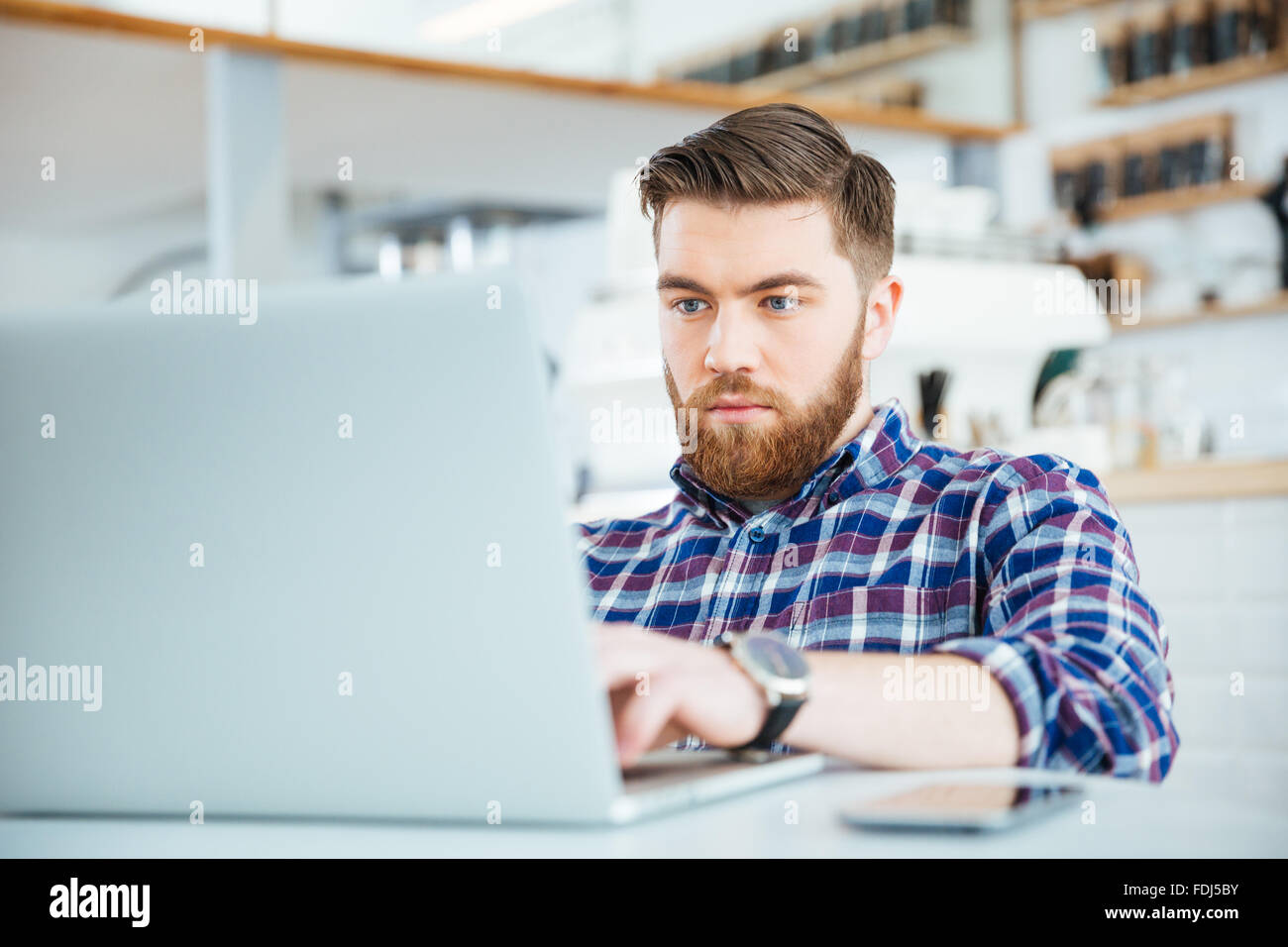 Man using laptop computer in coffee shop Stock Photo - Alamy