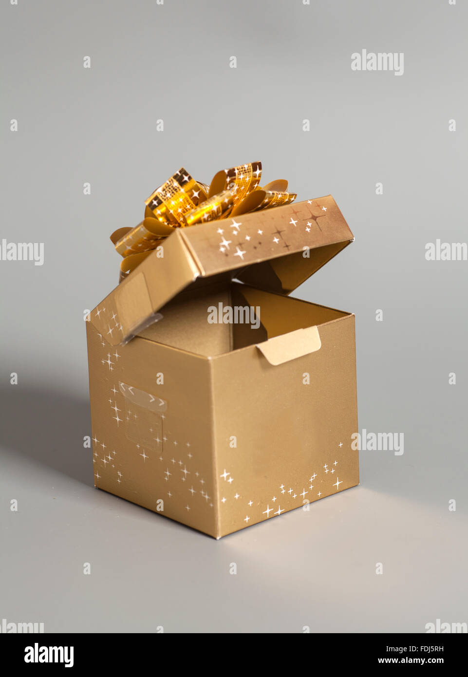 Open Golden gift box with golden ribbon on gray background Stock Photo ...