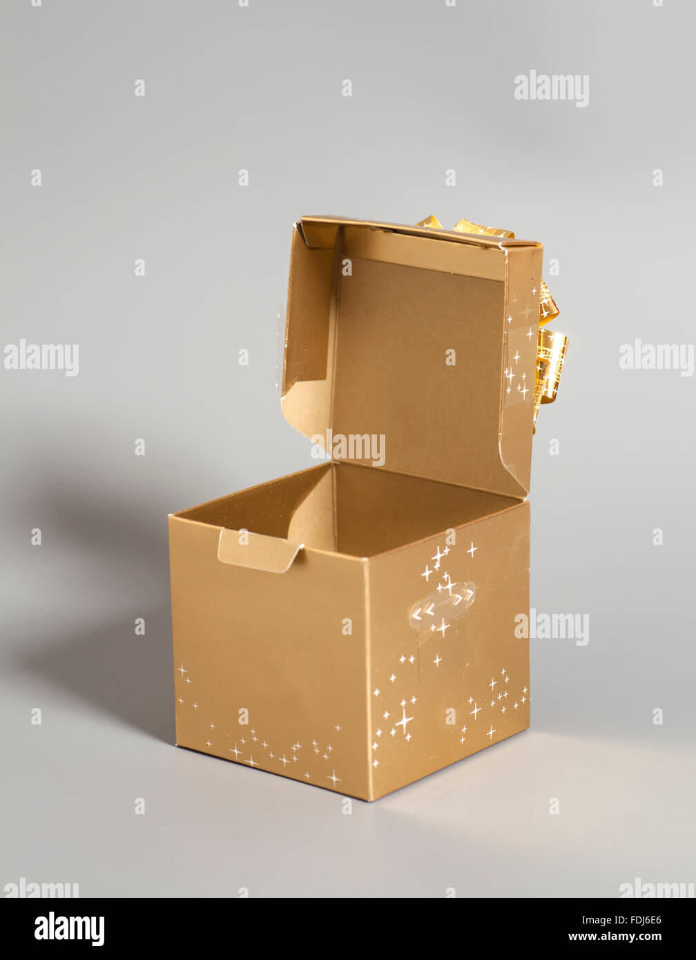 Open Golden gift box on gray background Stock Photo - Alamy
