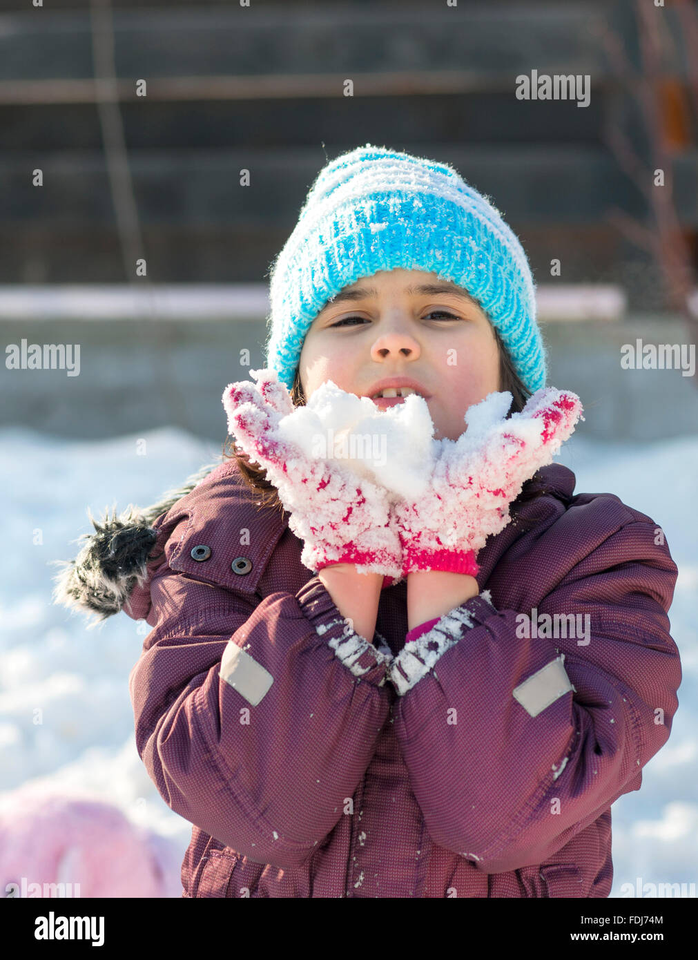 Little girl playing with snow Stock Photo - Alamy