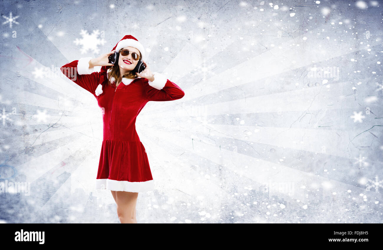 Young attractive Santa girl listening music in headphones Stock Photo ...