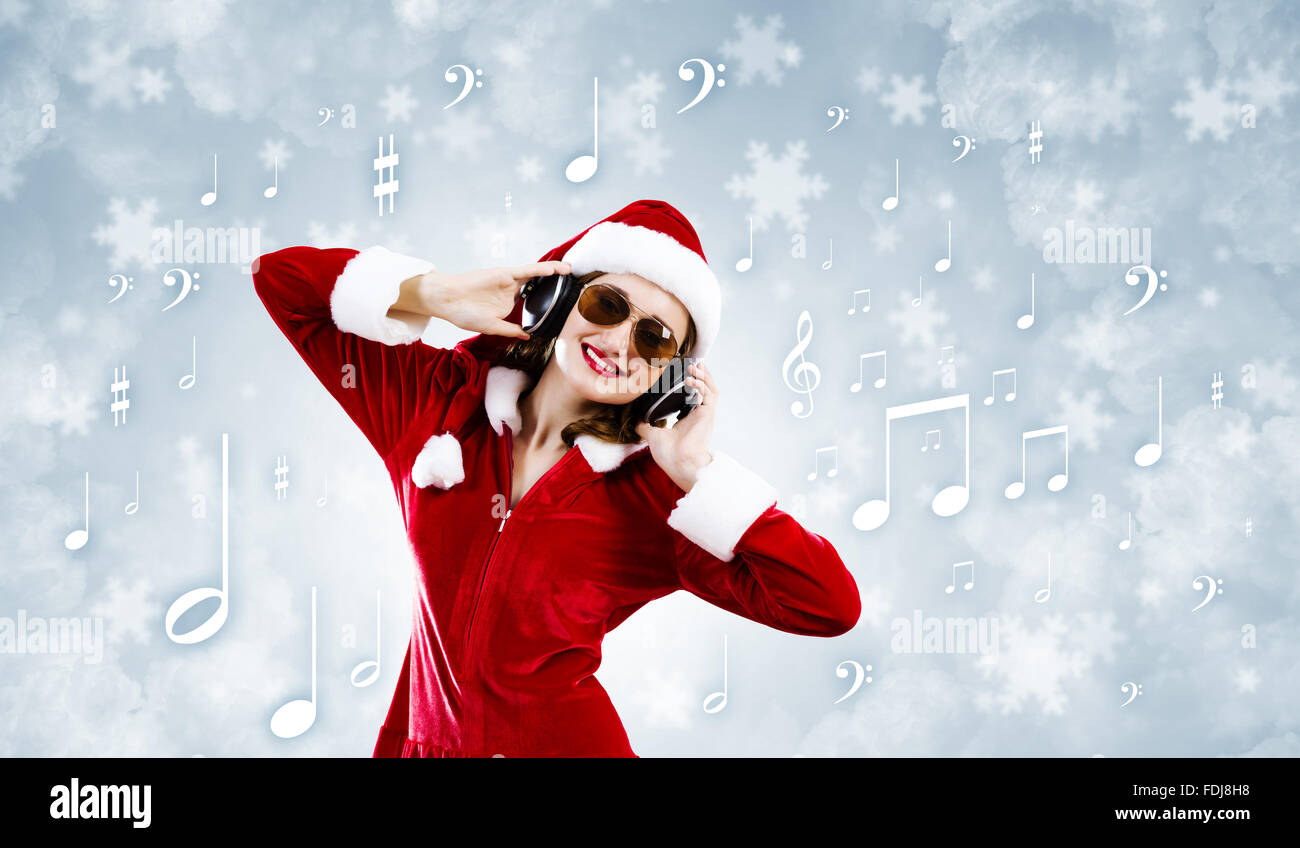Young attractive Santa girl listening music in headphones Stock Photo ...
