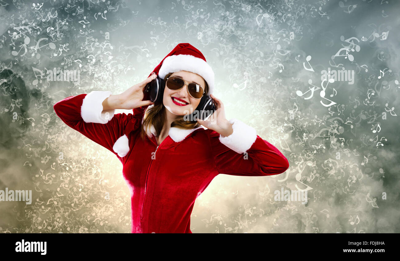 Young attractive Santa girl listening music in headphones Stock Photo ...