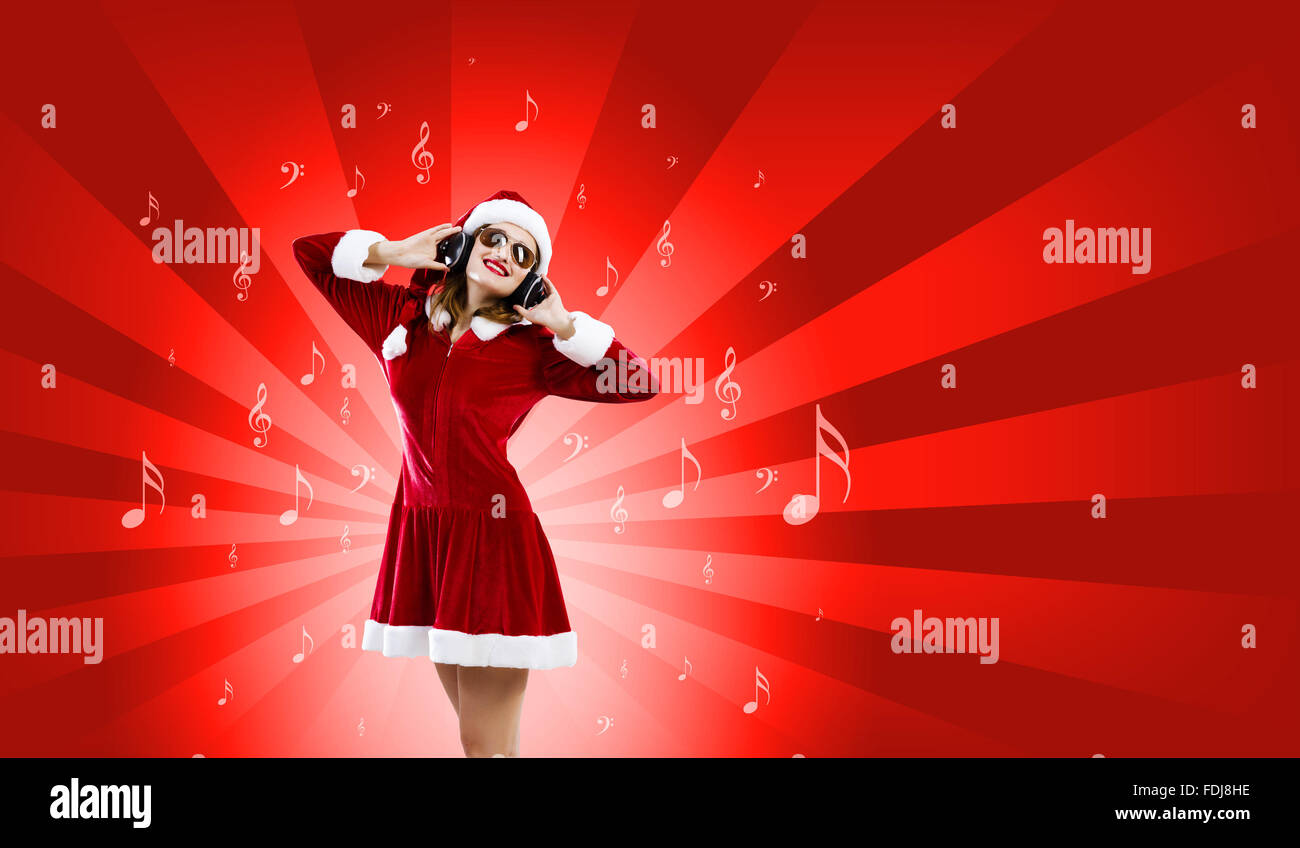 Young attractive Santa girl listening music in headphones Stock Photo ...