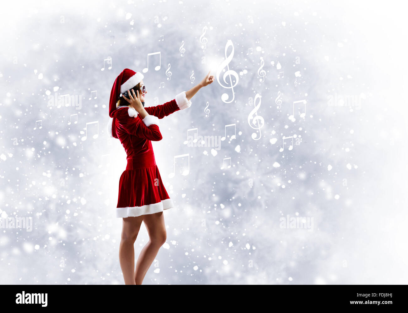Young attractive Santa girl listening music in headphones Stock Photo ...