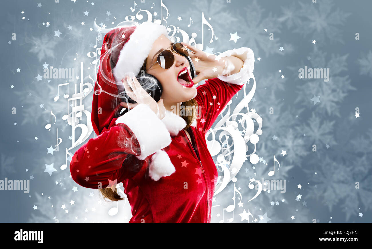 Young attractive Santa girl listening music in headphones Stock Photo ...