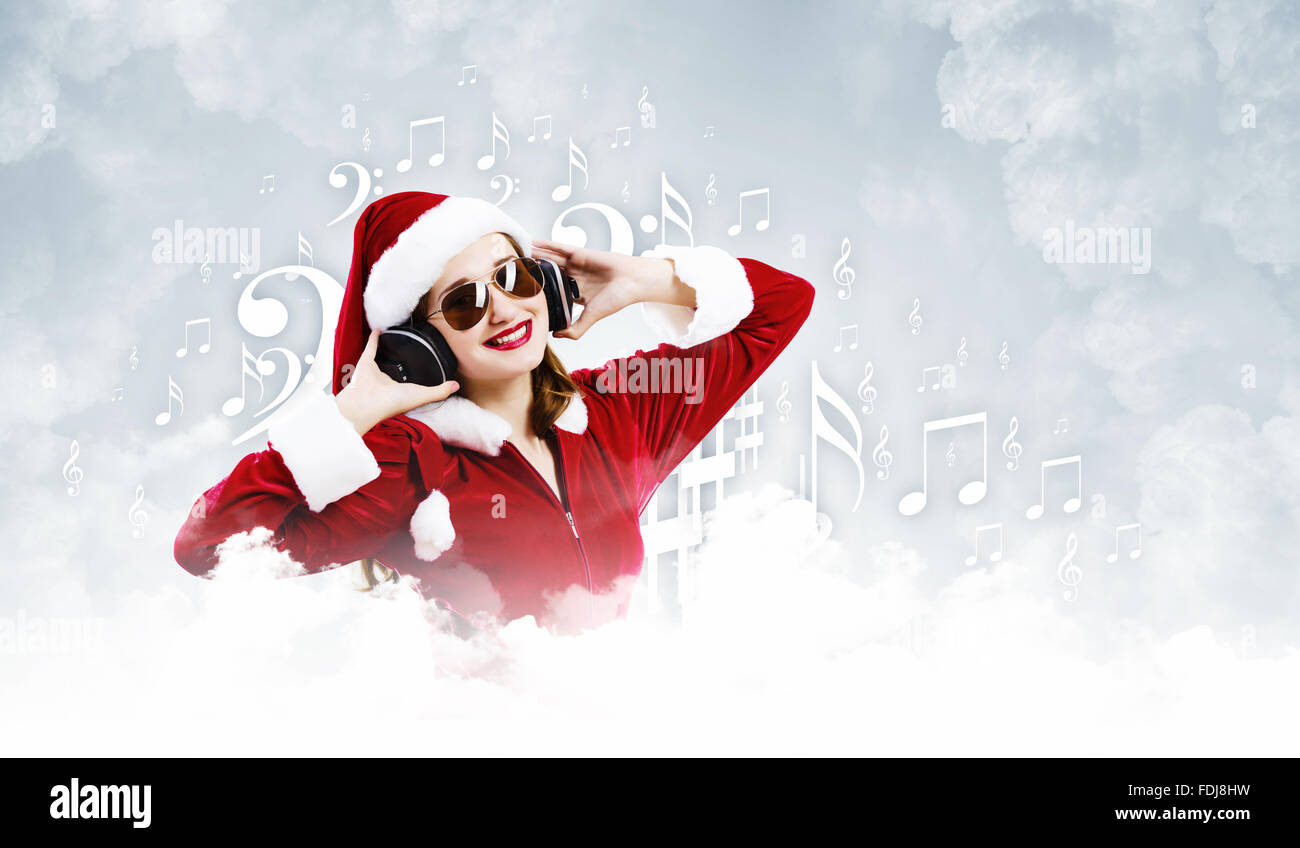 Young attractive Santa girl listening music in headphones Stock Photo ...
