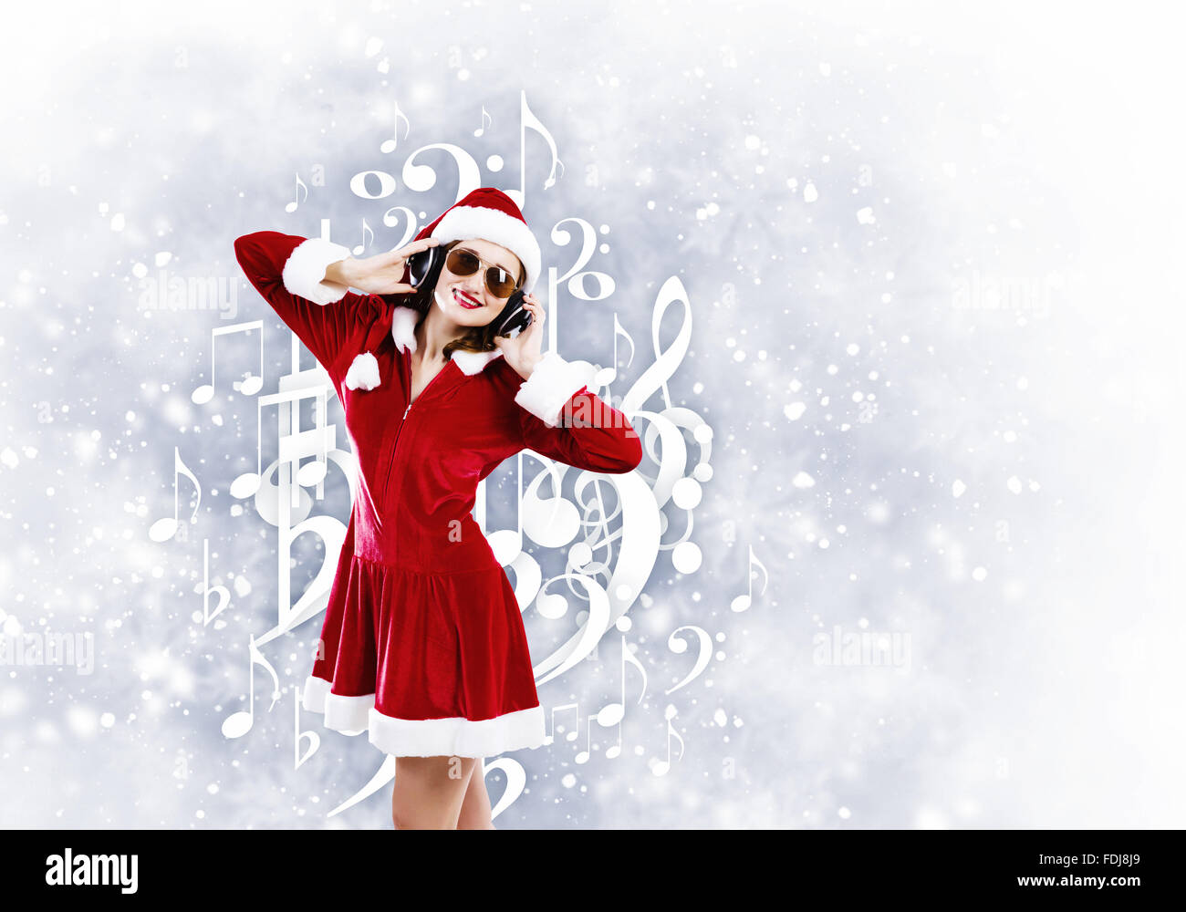 Young attractive Santa girl listening music in headphones Stock Photo ...