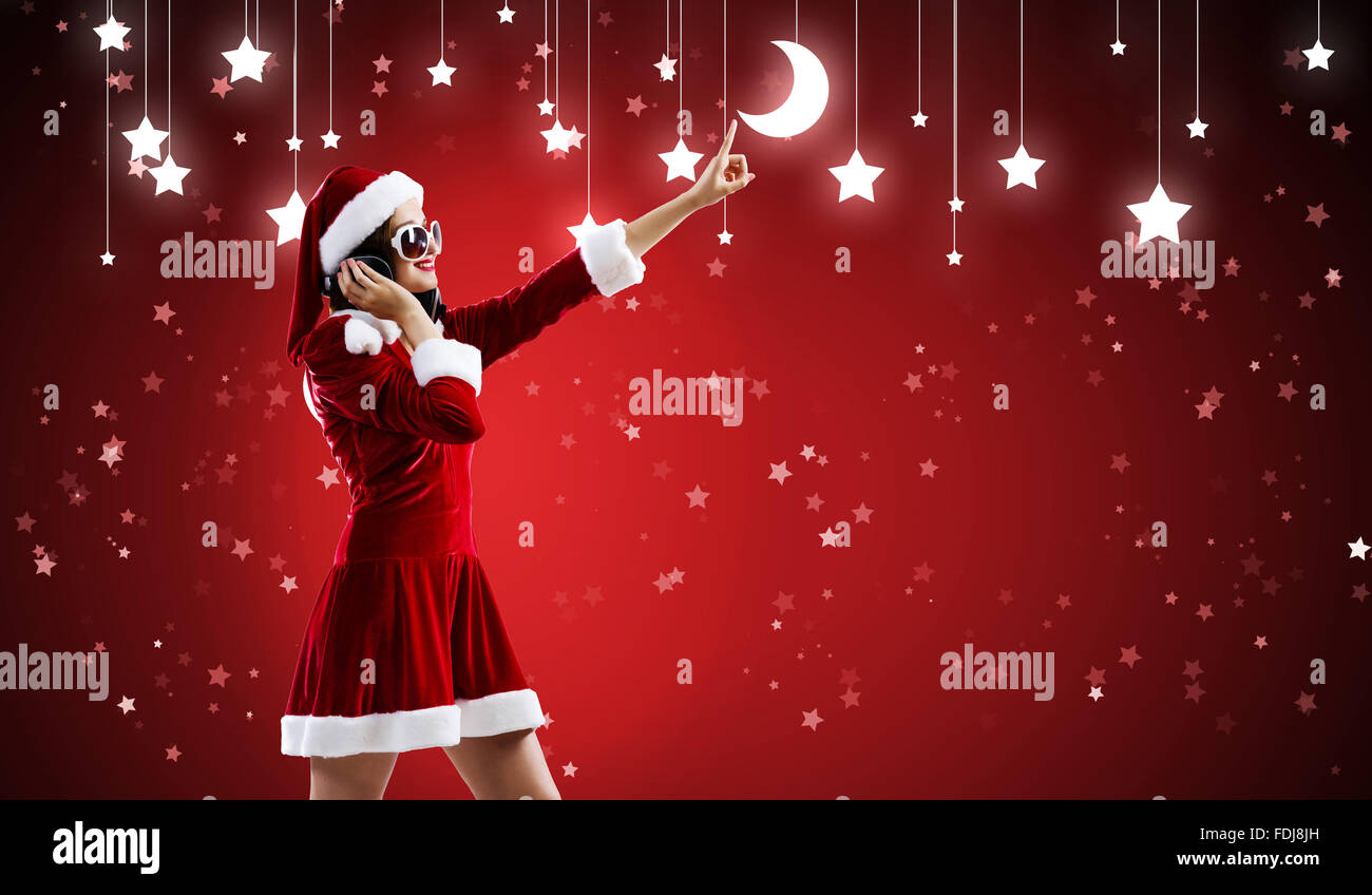 Young attractive Santa girl listening music in headphones Stock Photo ...