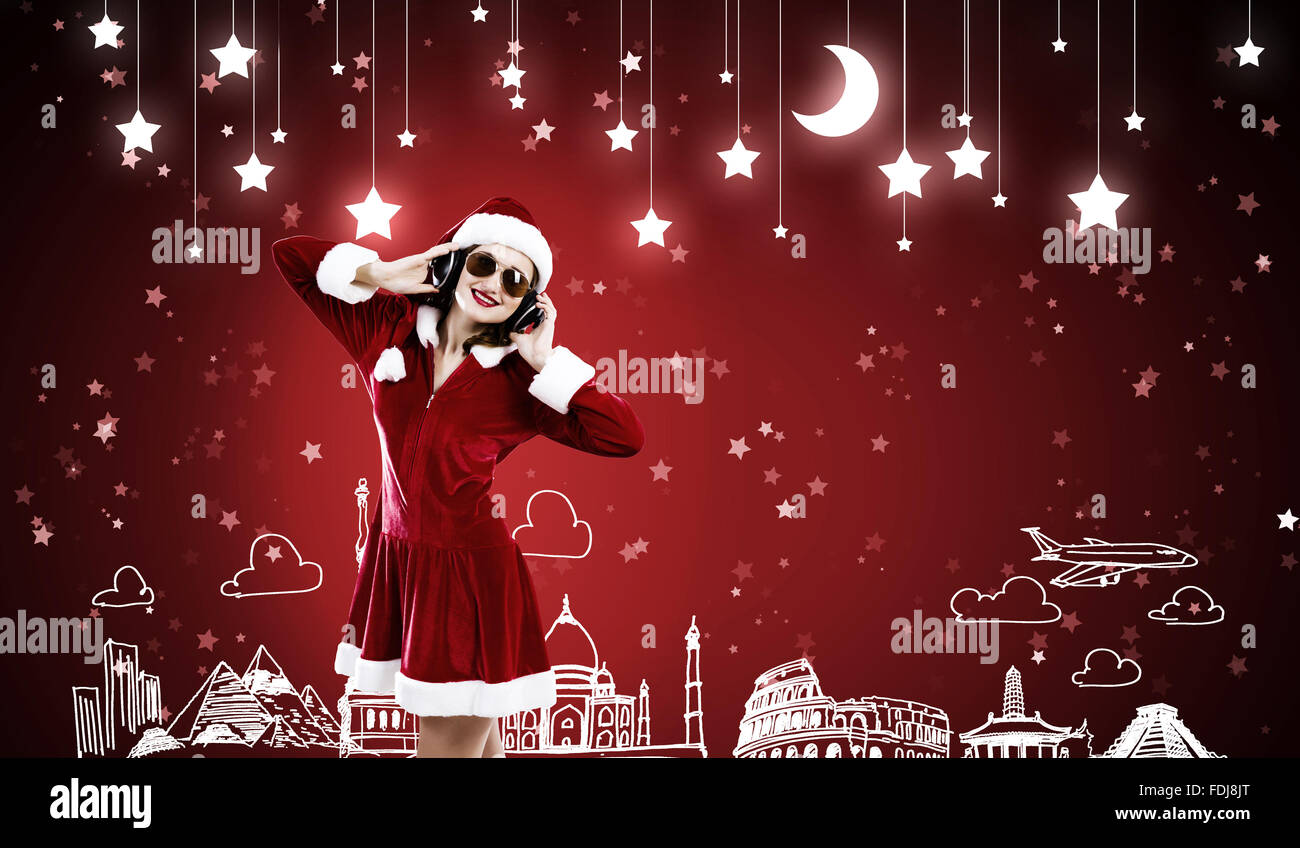 Young attractive Santa girl listening music in headphones Stock Photo ...
