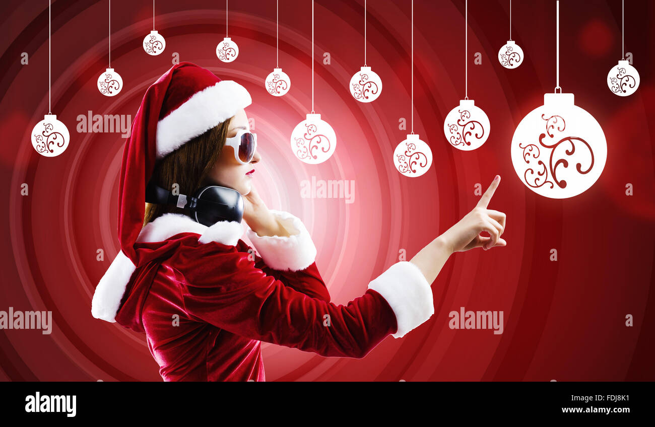 Young attractive Santa girl listening music in headphones Stock Photo ...