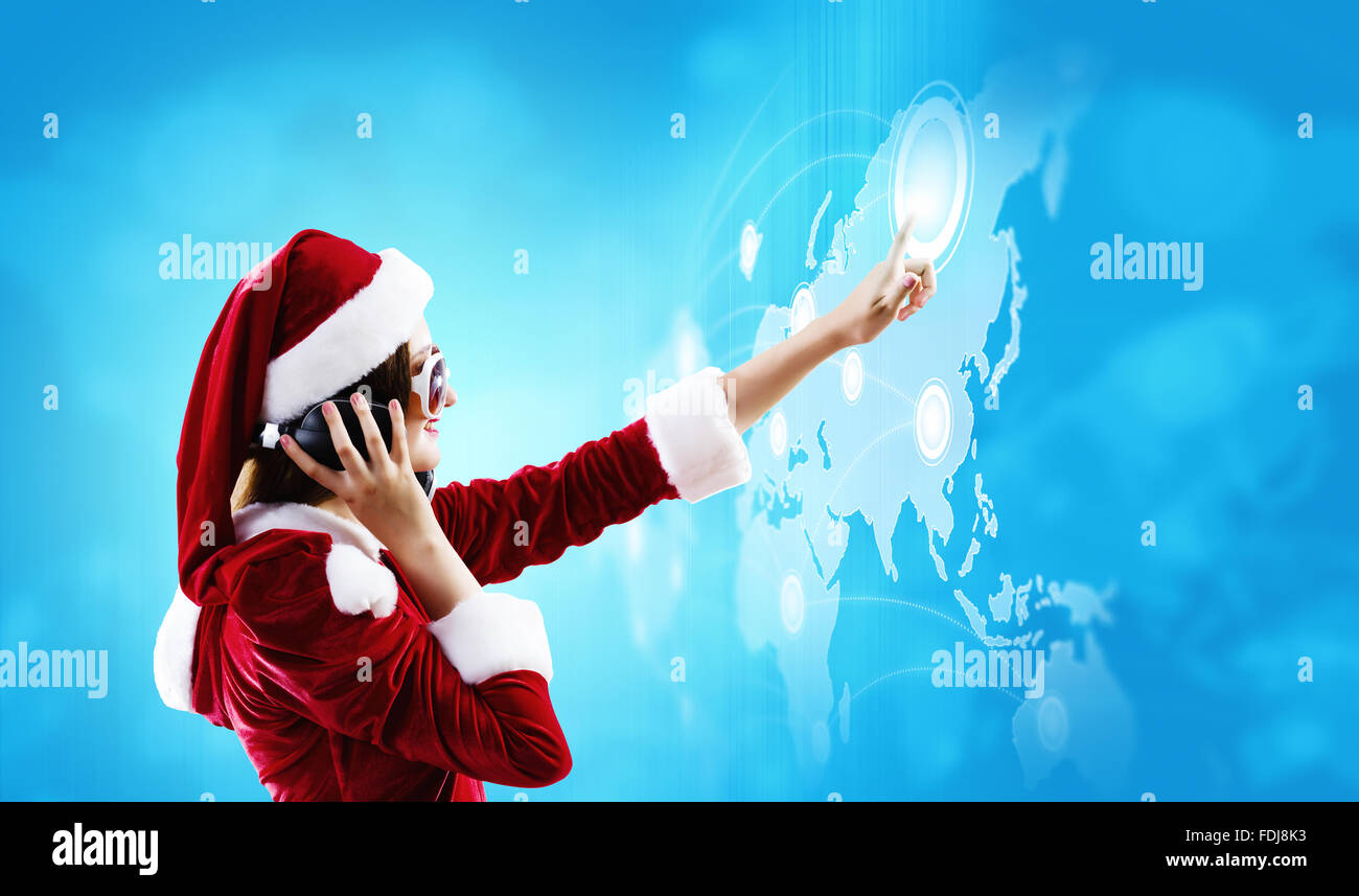 Young attractive Santa girl listening music in headphones Stock Photo ...
