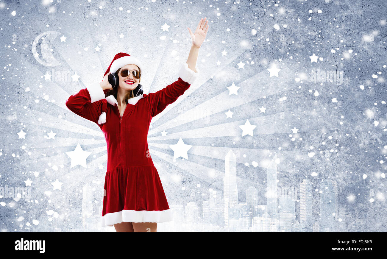 Young attractive Santa girl listening music in headphones Stock Photo ...