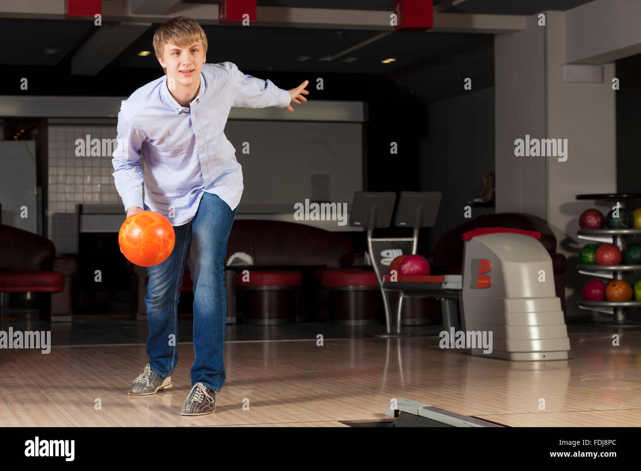 Young guy at bowling club throwing ball Stock Photo - Alamy