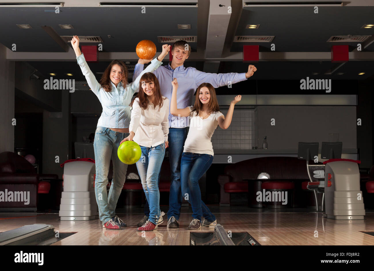 Group of four young smiling people playing bowling Stock Photo - Alamy