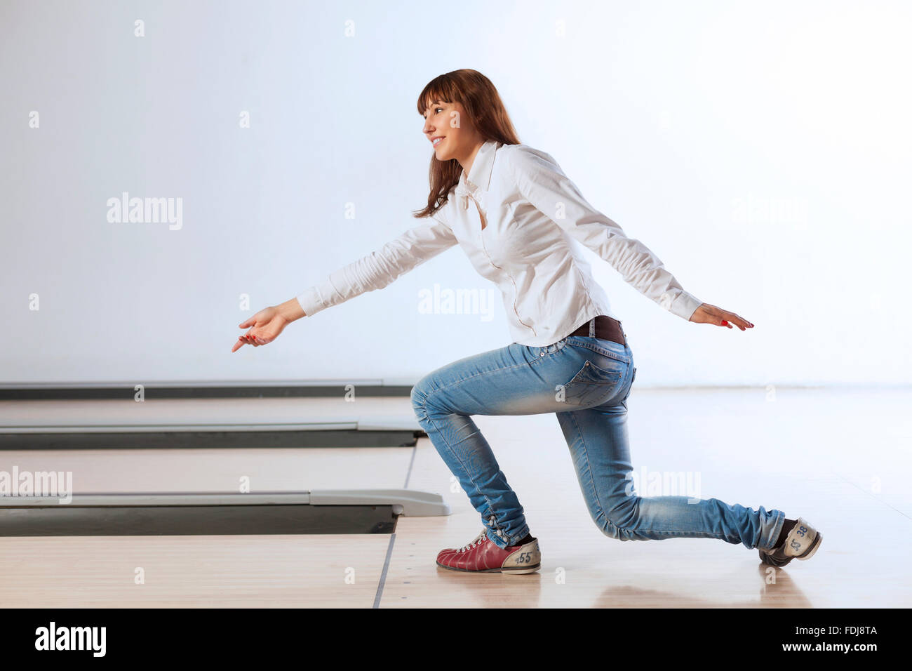 Young pretty woman throwing a bowling ball Stock Photo - Alamy