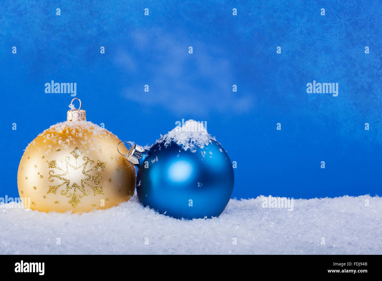 gold Christmas balls in the snow Stock Photo - Alamy