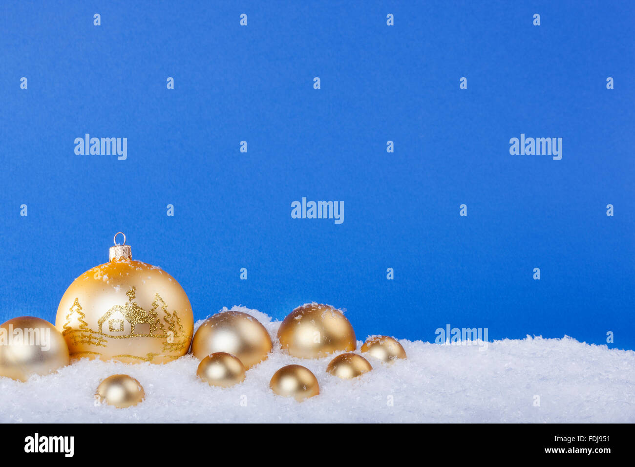 gold Christmas balls in the snow Stock Photo - Alamy
