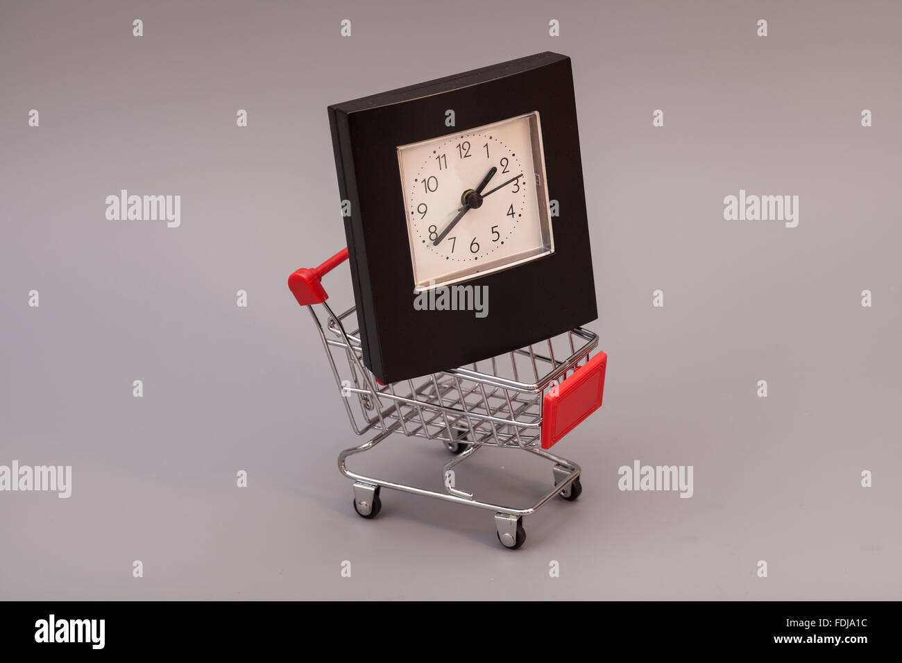 Shopping Cart with Alarm Clock on gray background Stock Photo - Alamy