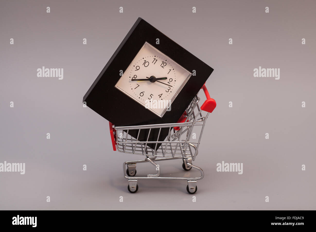 Shopping Cart with Alarm Clock on gray background Stock Photo - Alamy