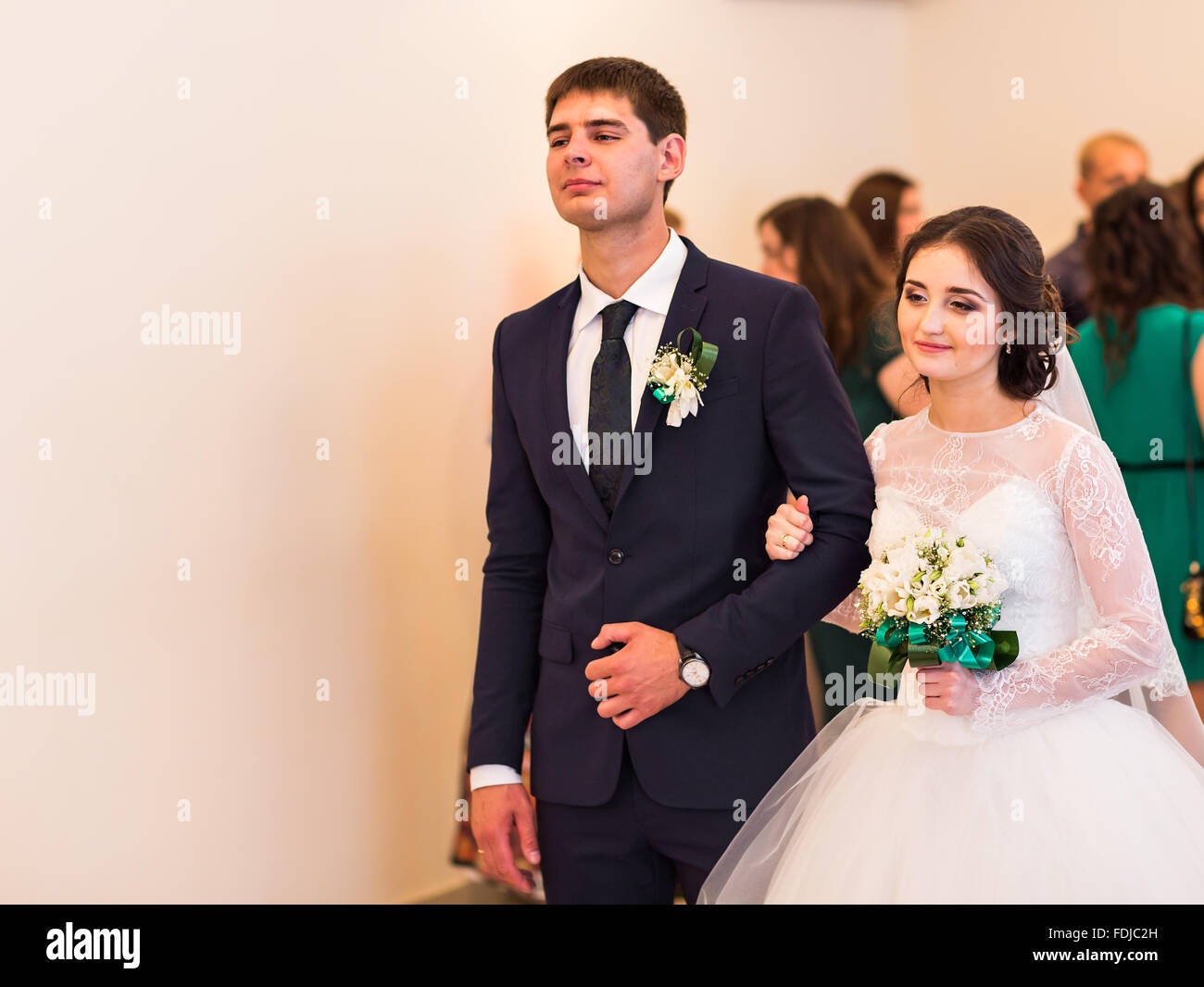 Bride and groom are holding each other's hands during wedding ceremony ...