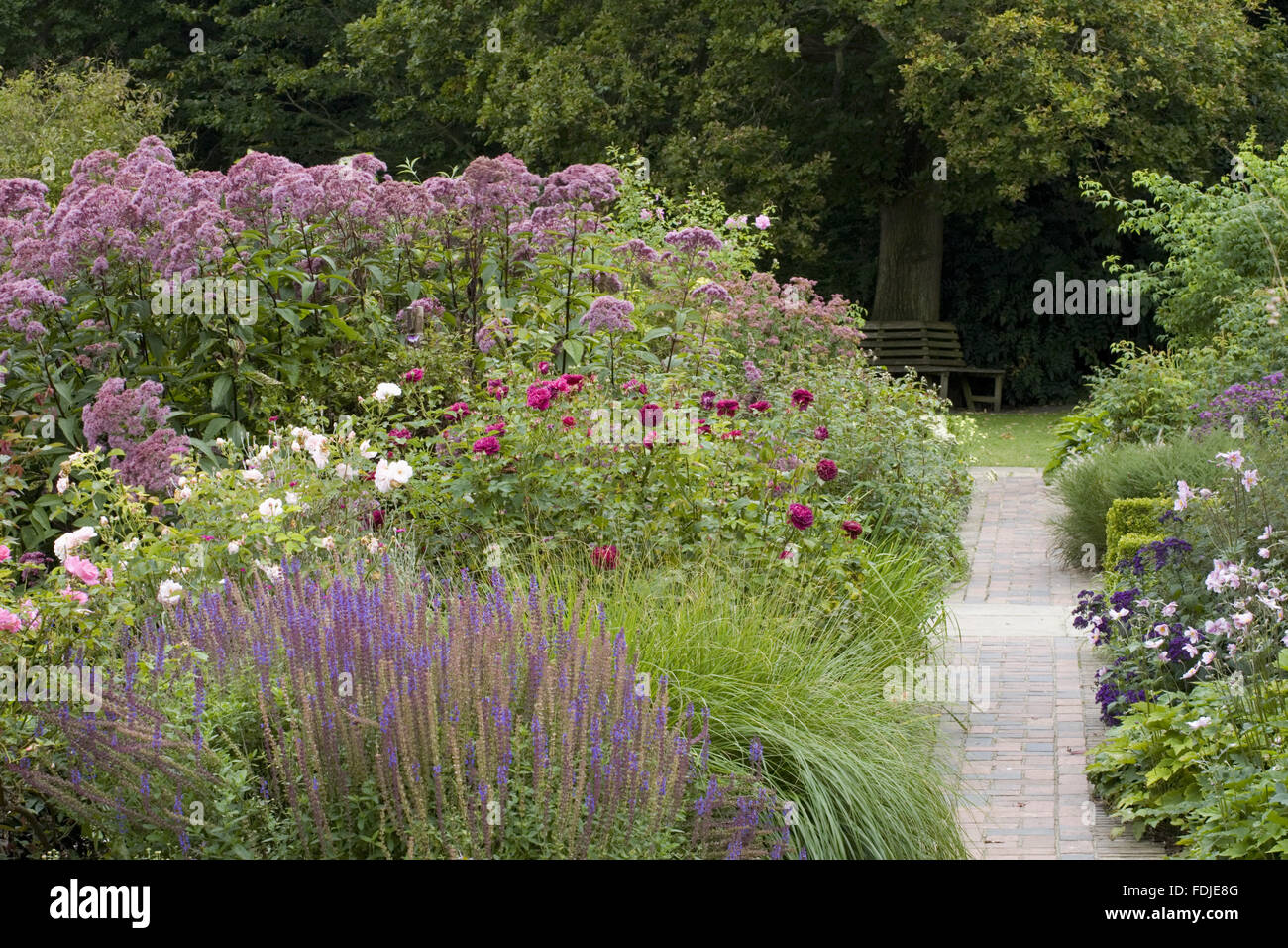 Narrow paved path in the Rose Garden in late summer at Sissinghurst ...