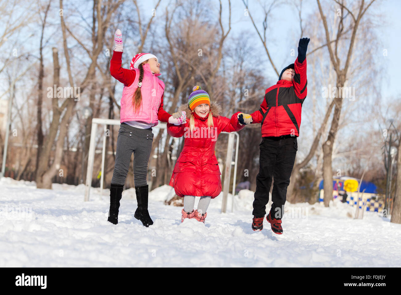 Cute children jumping and having fun in winter park Stock Photo - Alamy